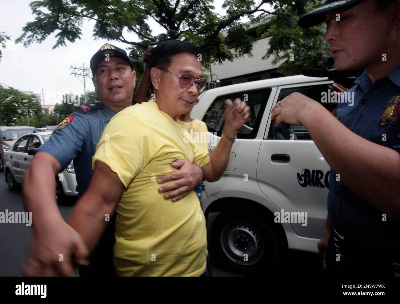 Abner Afuang, center, a former policeman, is stopped by police from ...