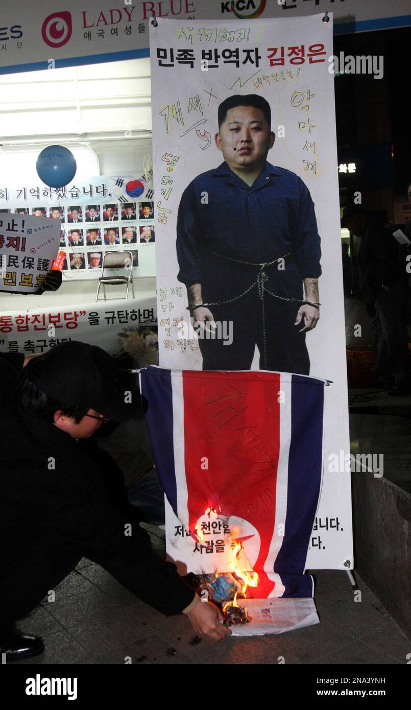 A South Korean protester burns a North Korean flag in front of a ...