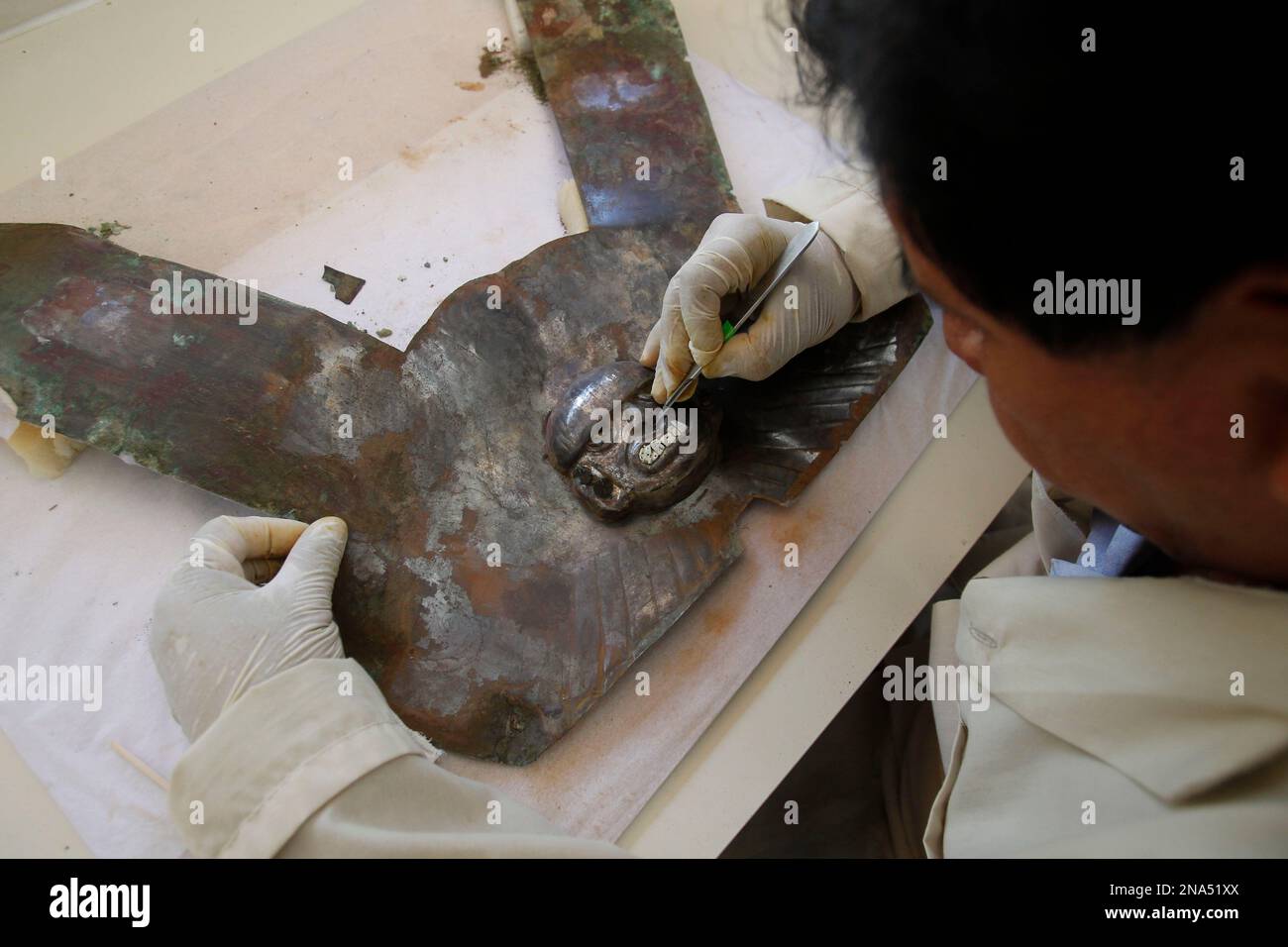A restaurateur cleans a diadem that was discovered in the 1,500-year ...