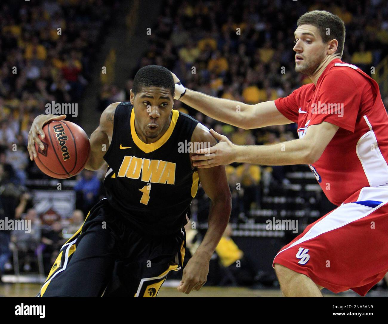 Iowa forward Melsahn Basabe drives past Dayton forward Alex Gavrilovic ...
