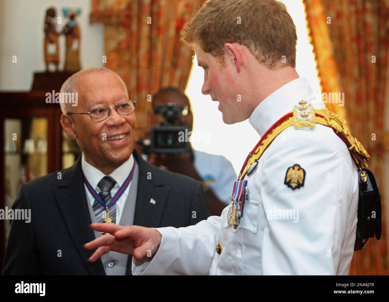 Britain's Prince Harry, rught, speaks to Sir Arthur Foulkes, governor ...