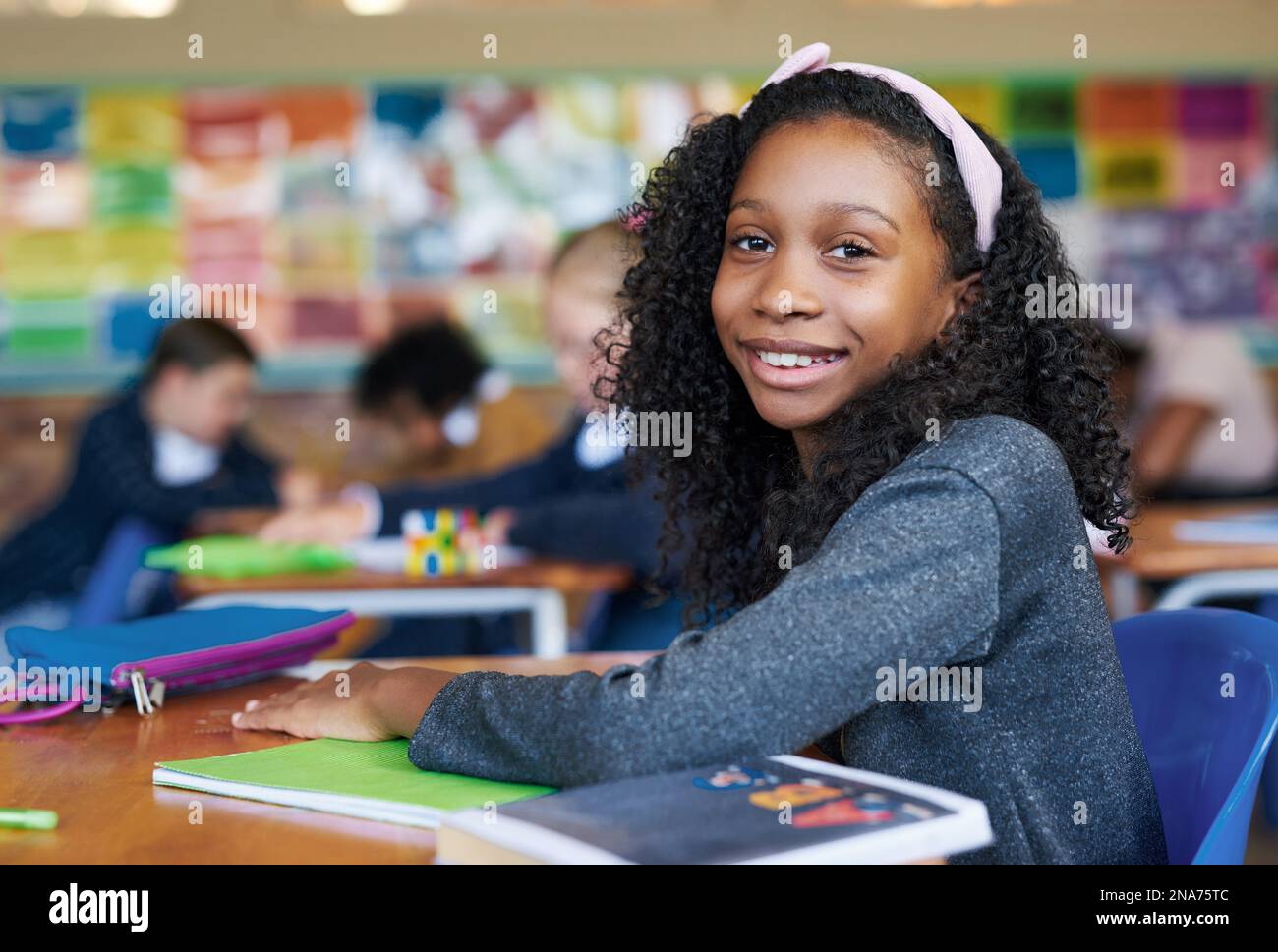 Apprendre Est Amusant Ici Une Jeune Fille Assise à Son Bureau Dans Sa Salle De Classe à Lécole