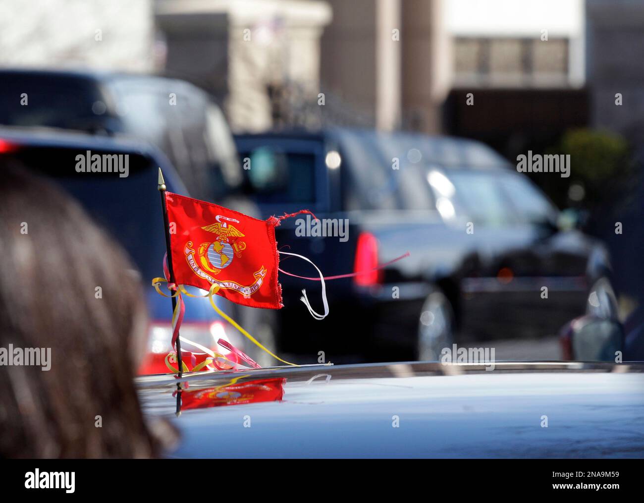A small U.S. Marine Corps flag falps in a breeze as the hearse bearing the casket of Lance Cpl ...