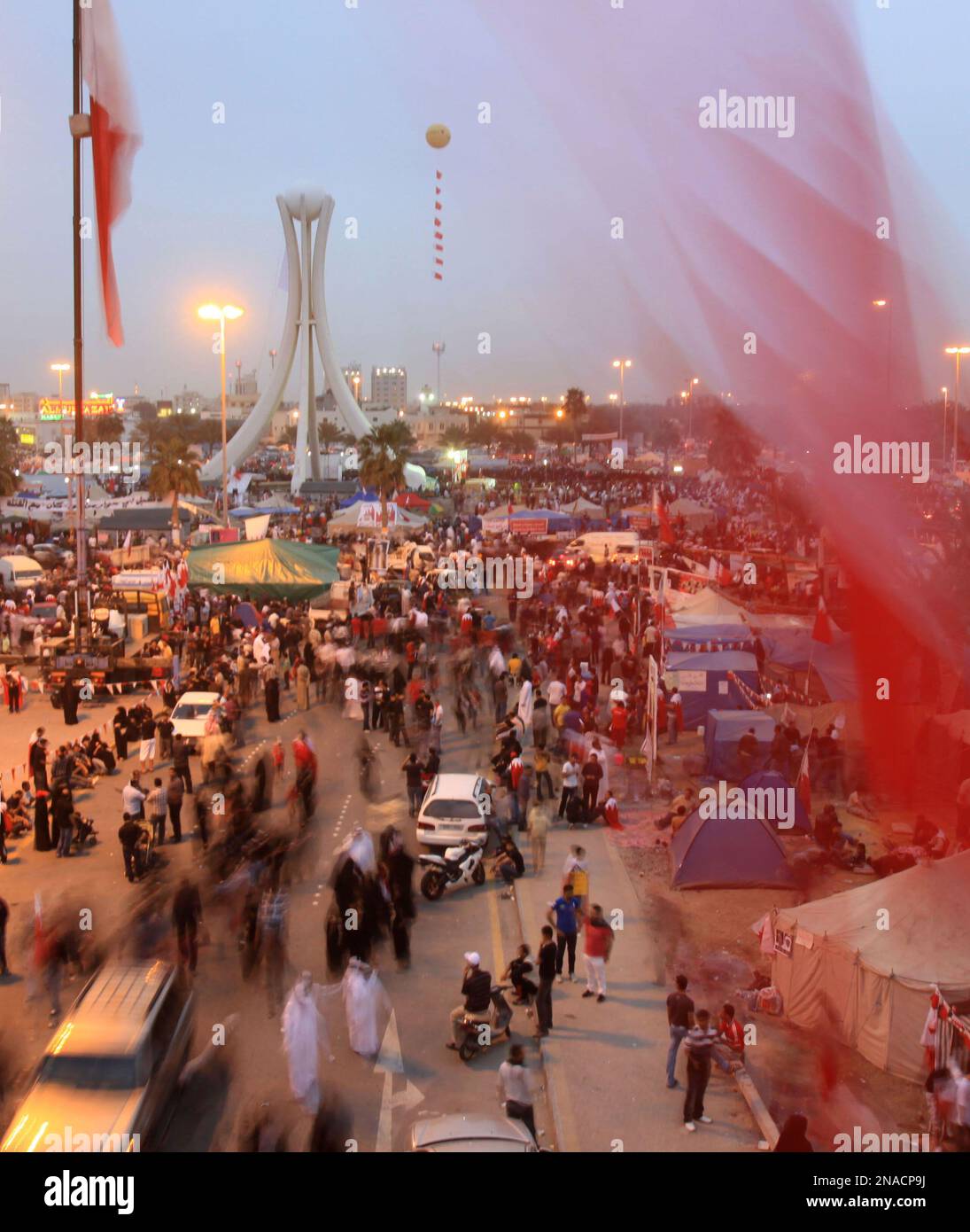 In this Friday, Feb. 25, 2011 photo, people gather and wave national ...