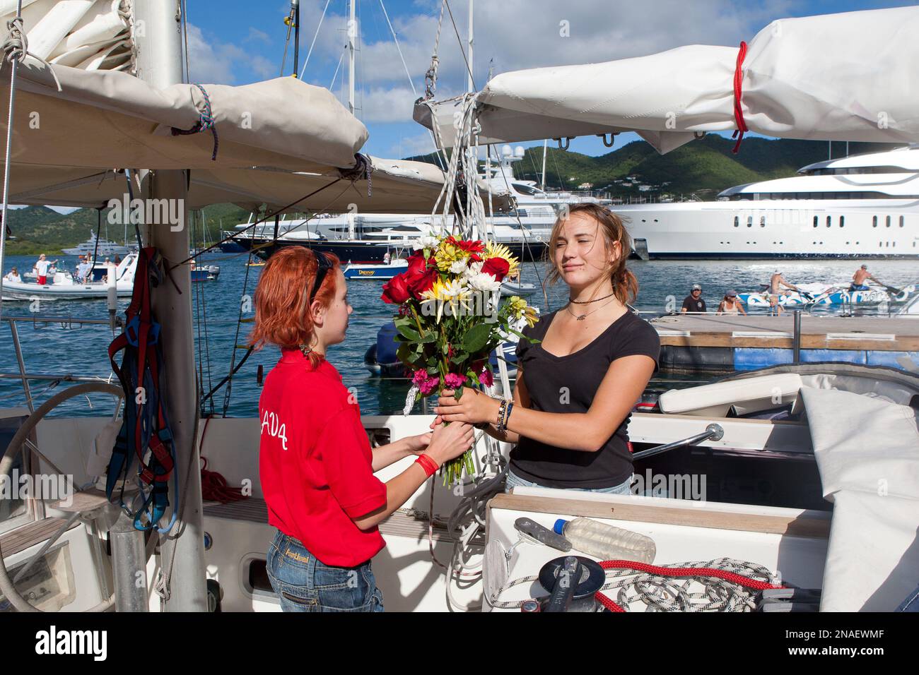 Teen sailor Laura Dekker, right, receives a flower bouquet from her ...