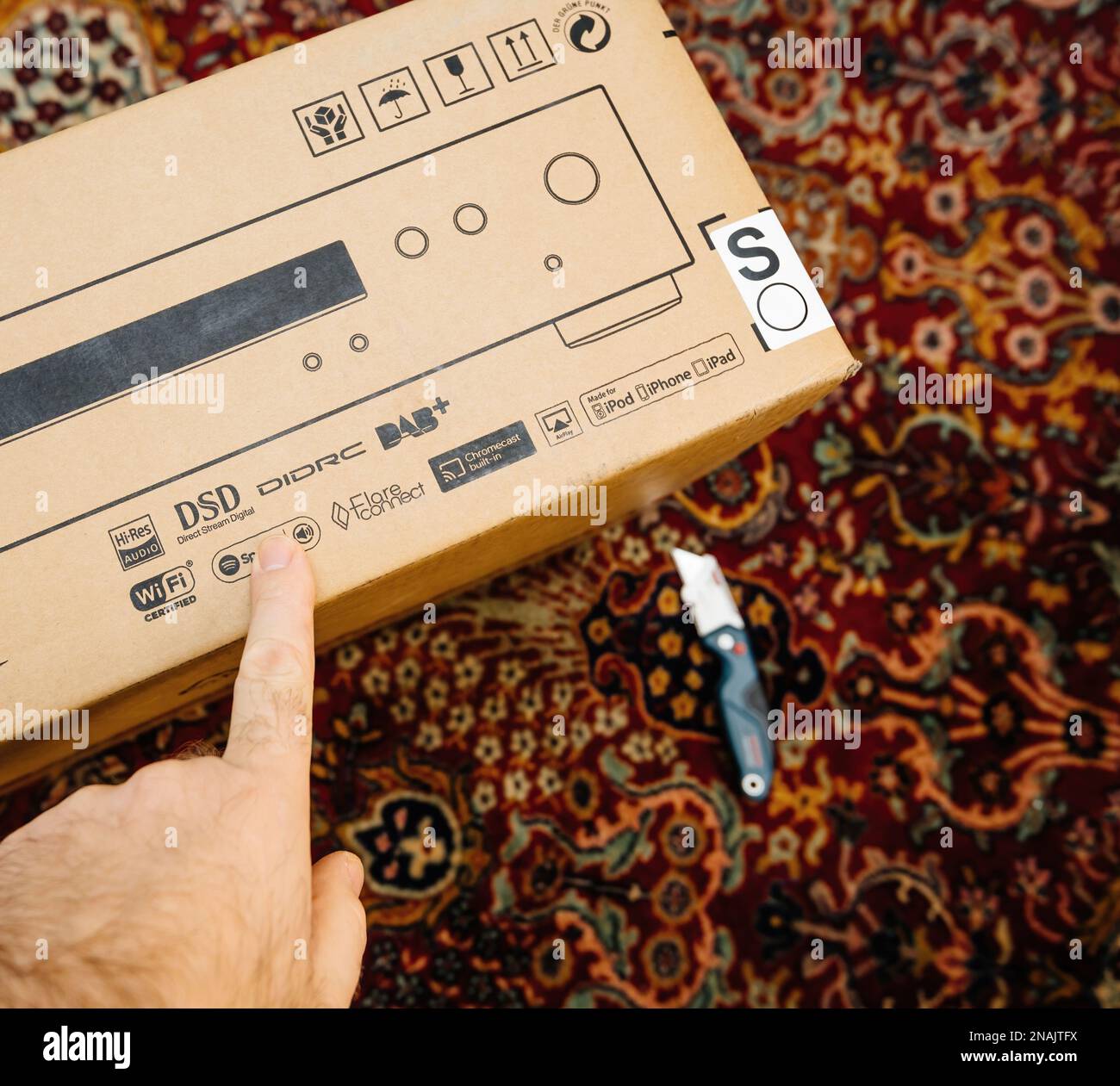 Paris, France - 13 décembre 2022 : la main mâle POV pointant vers Spotify DSD sur l'emballage en ...
