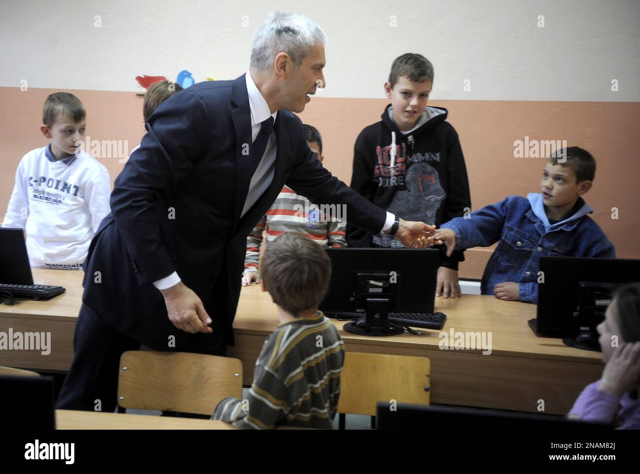 Serbian President Boris Tadic, center, greets children in a classroom ...