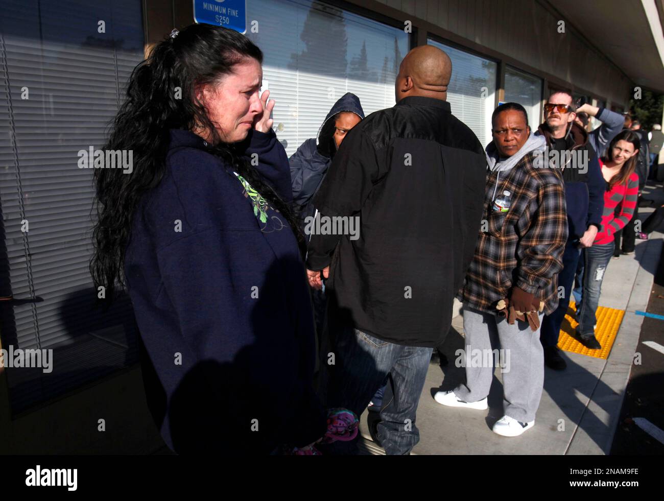 Brenda Helzer wipes a tear as she waits at the head of the line for the ...