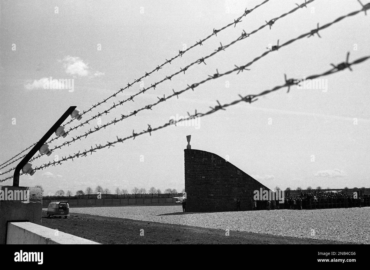 Barbed wire in foreground is a grim reminder of the past at dedication ...