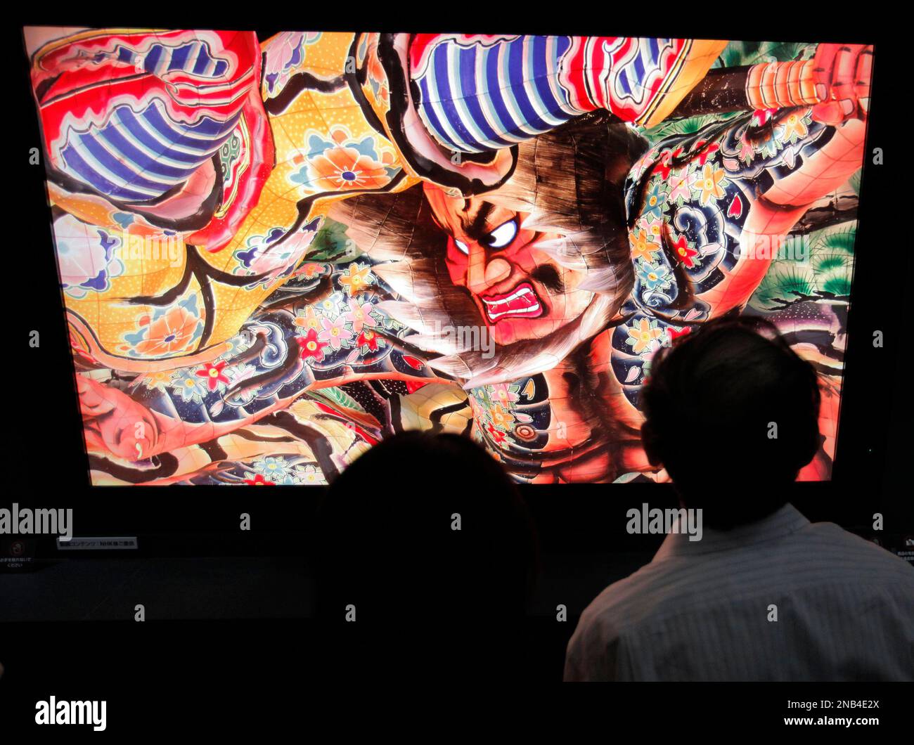 Visitors look at a colorful float of a Japanese festival shown on Sharp ...
