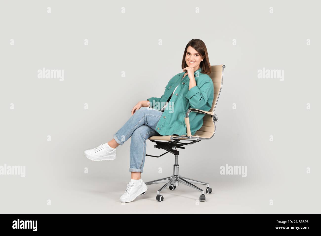 Jeune femme assise dans une chaise de bureau Banque de photographies et d’images à haute ...