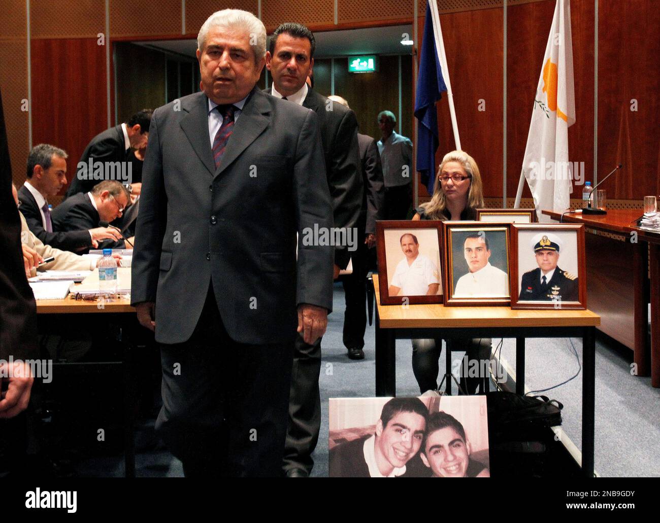 Cypriot president Dimitris Christofias walks by the pictures of people ...
