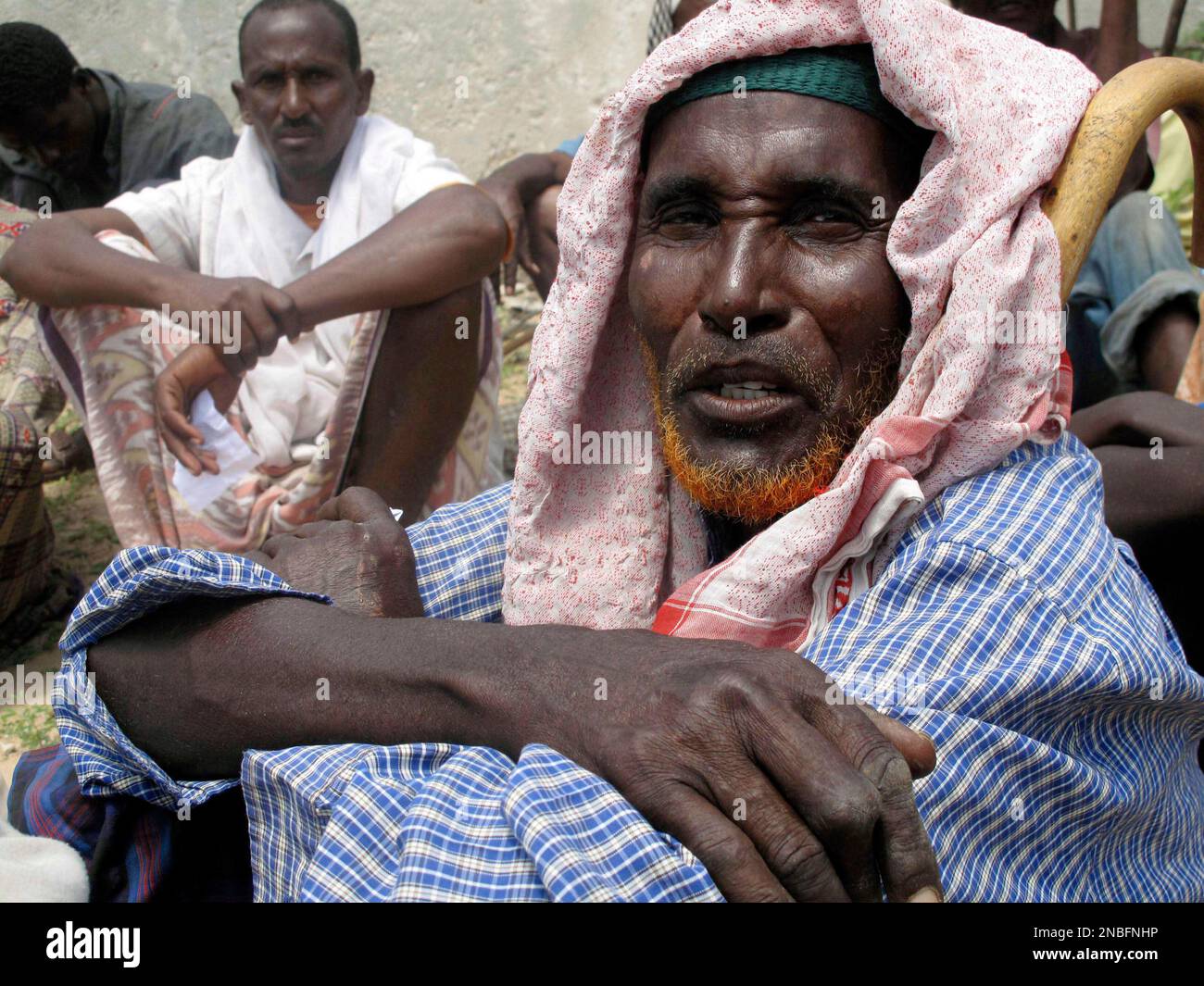 An elderly Somali man displaced by famine waits to receive food aid in ...