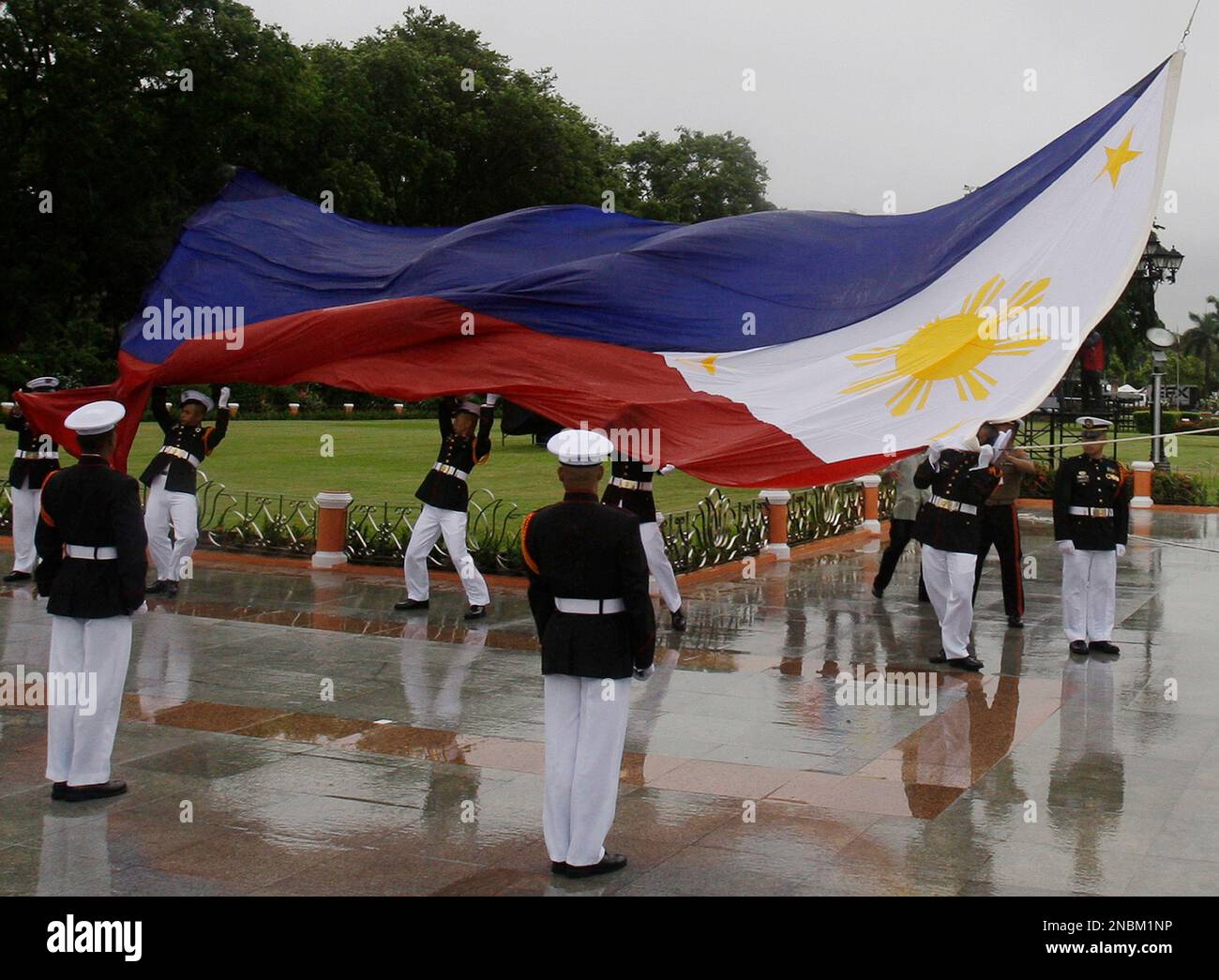 Filipino soldiers hold a large Philippine flag as it is blown by strong ...