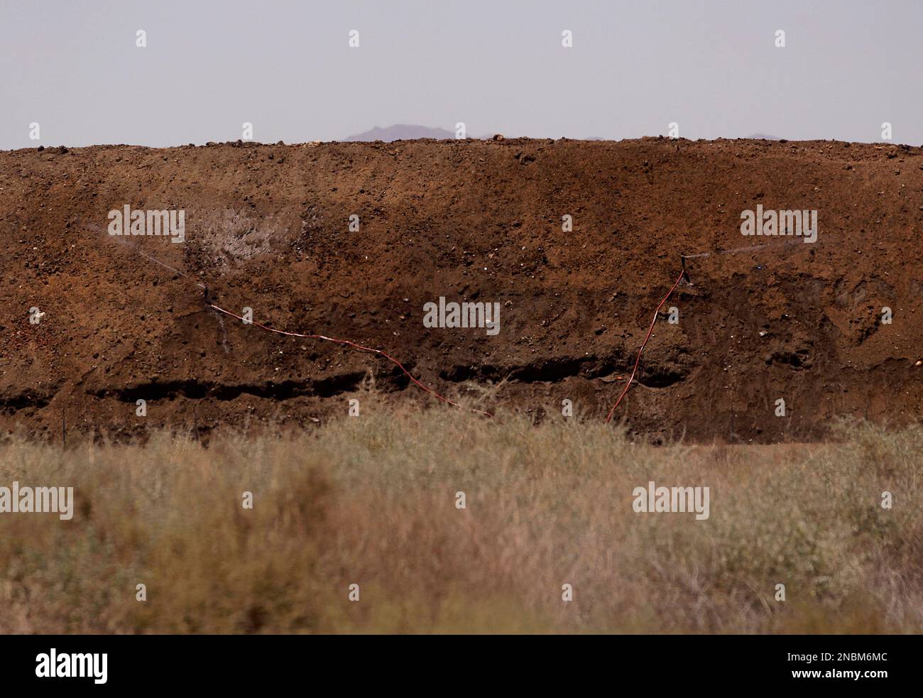 Sprinklers spray water on a pile of contaminated soil in Mecca, Calif ...