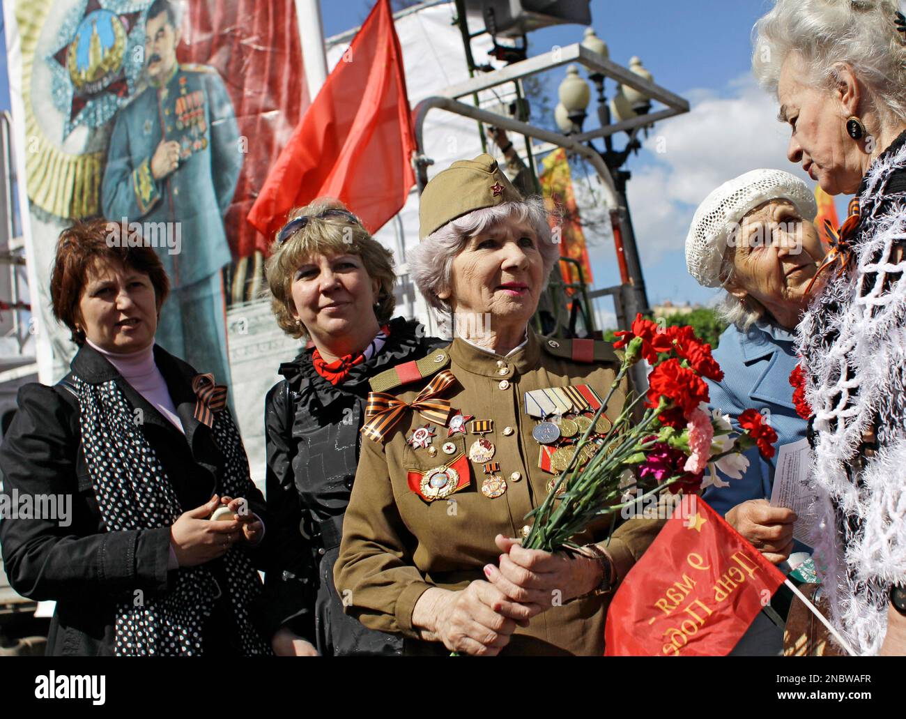 Women gather near the huge portrait of Soviet Dictator Josef Stalin ...