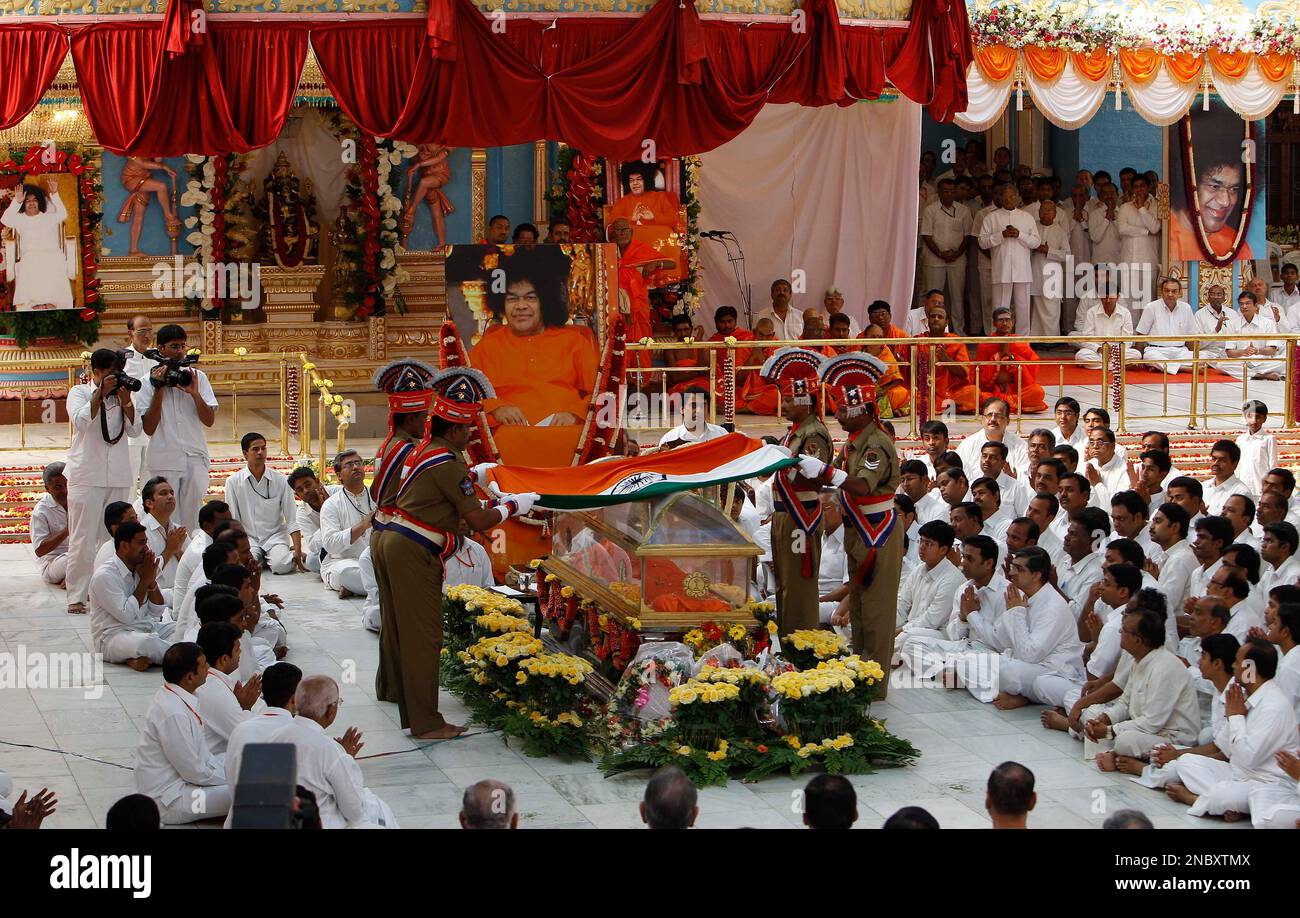 Policemen place an Indian flag on the casket containing the body of ...
