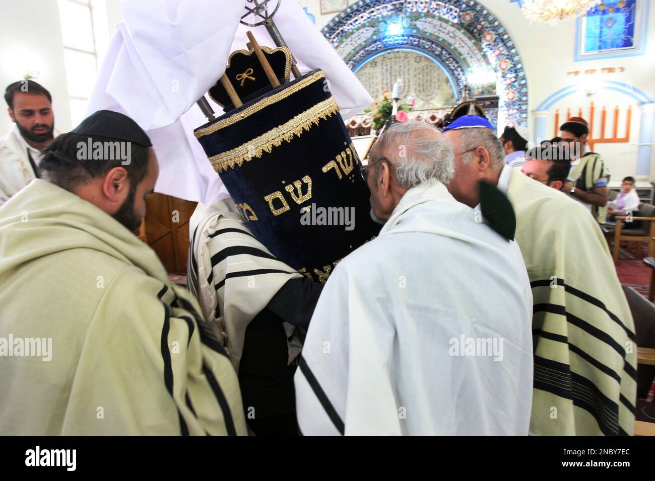 Iranian Jews kiss the Torah scroll in a morning service for Shabbat, on ...