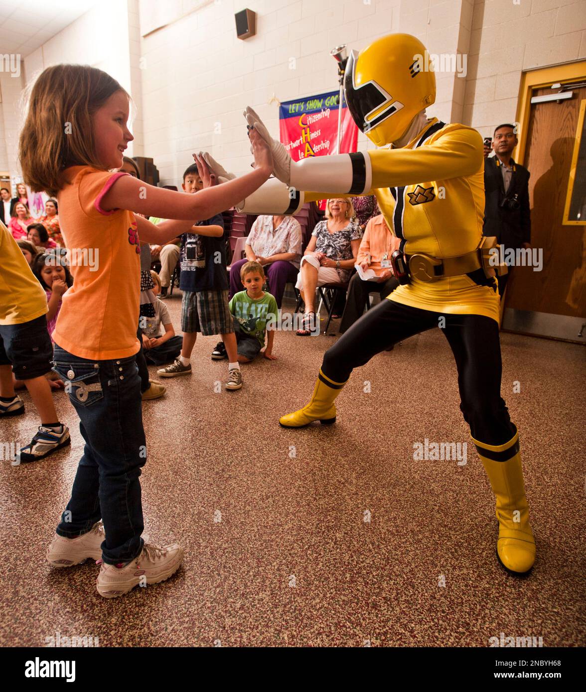 A students does an exercise with the yellow power ranger during an ...