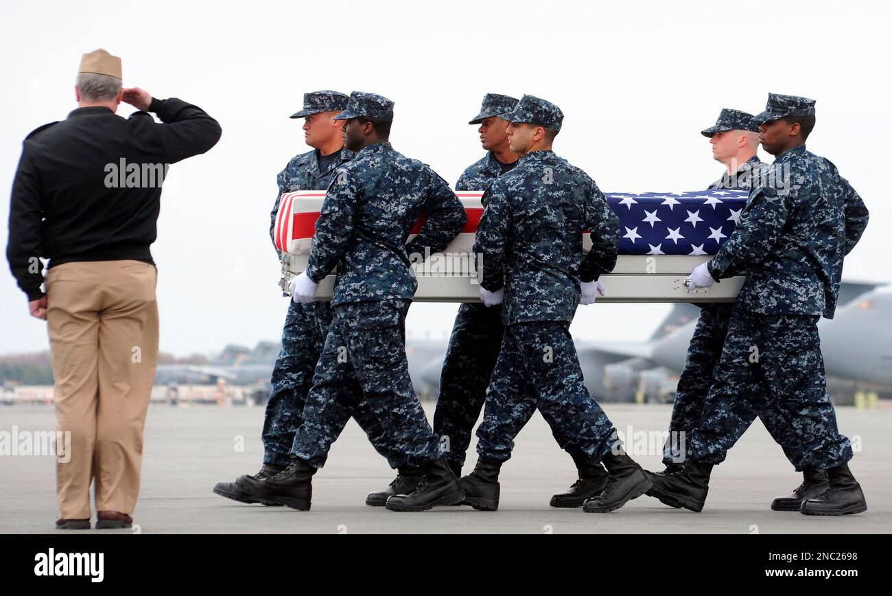 A Navy carry team moves a transfer case containing the remains of Petty ...