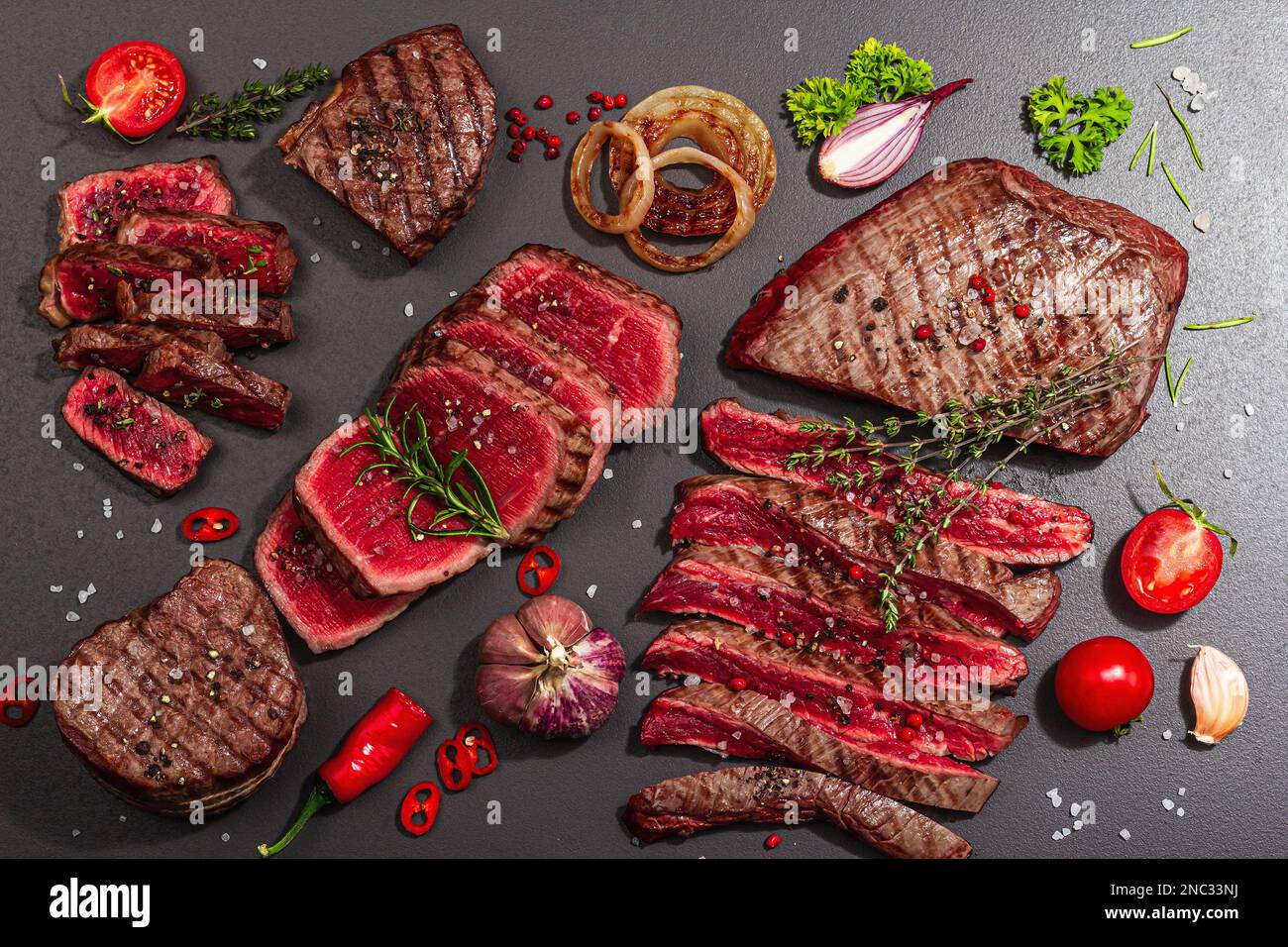 Ensemble de steaks grillés avec légumes, épices et herbes. Les viandes ...