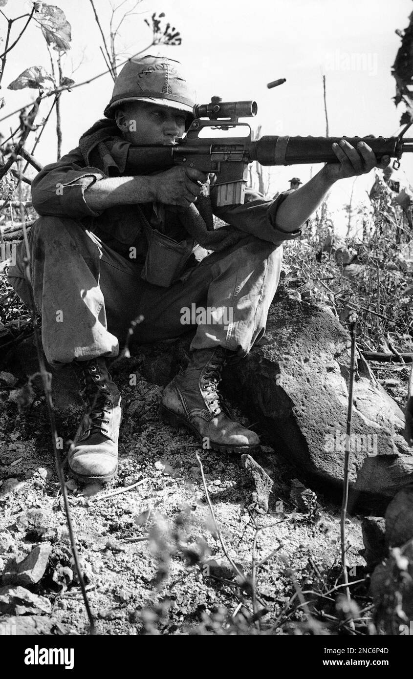 A spent cartridge flies from the breech of an M16 automatic rifle as an ...