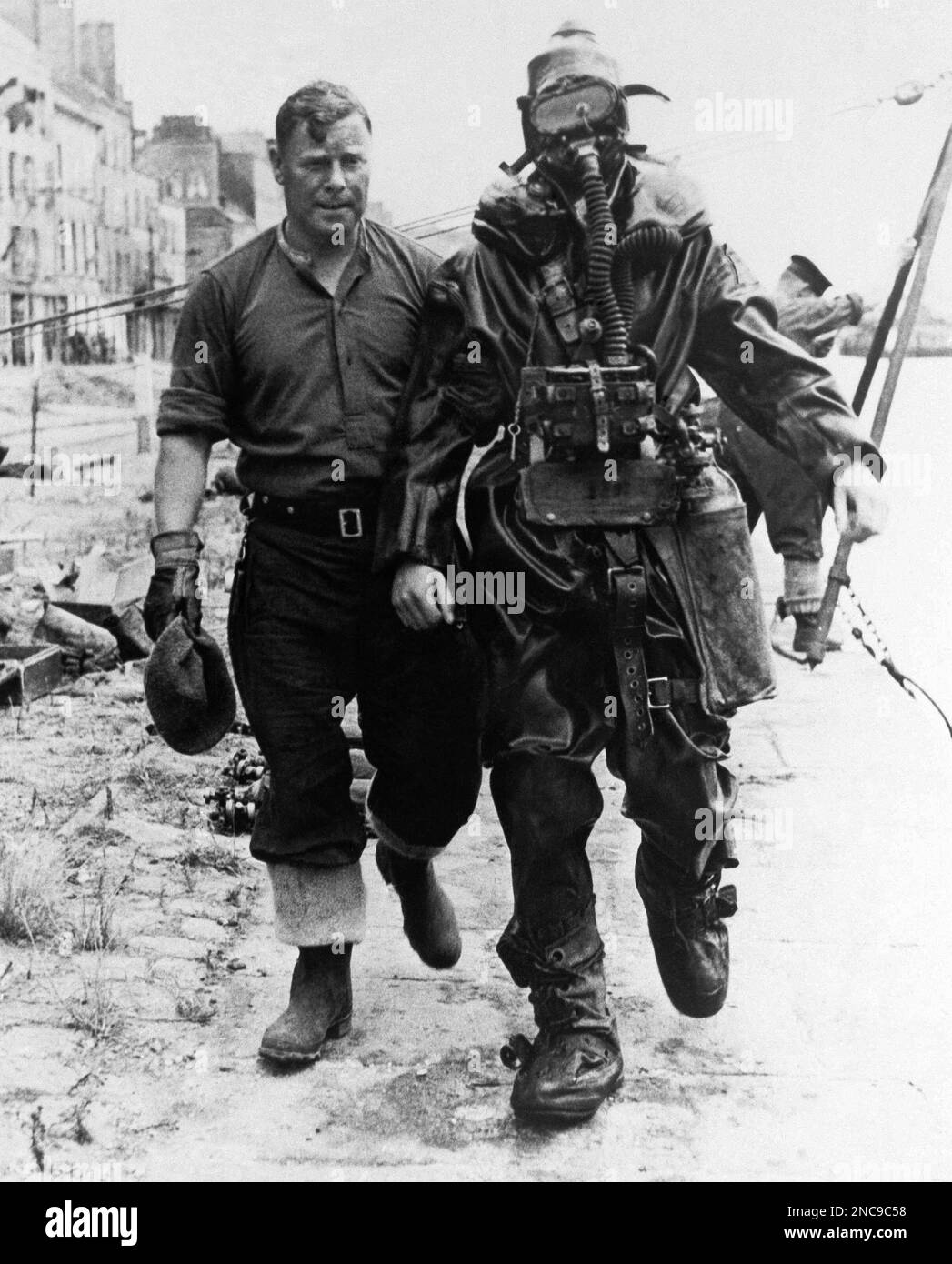 A diver of the British Royal Navy is walking down a pier of Cherbourg ...