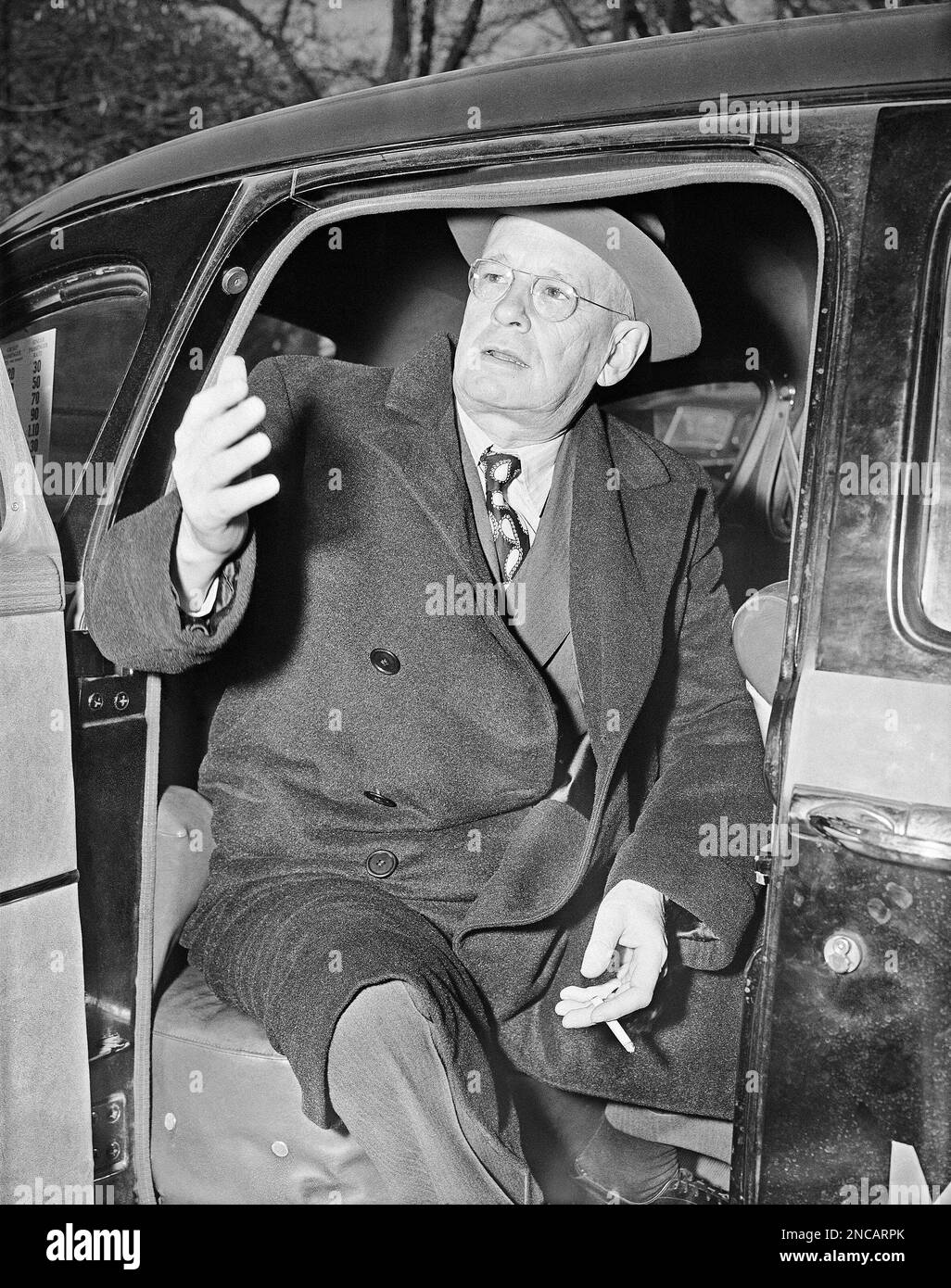 Former Governor Alf M. Landon of Kansas talks to newsmen from a taxicab ...