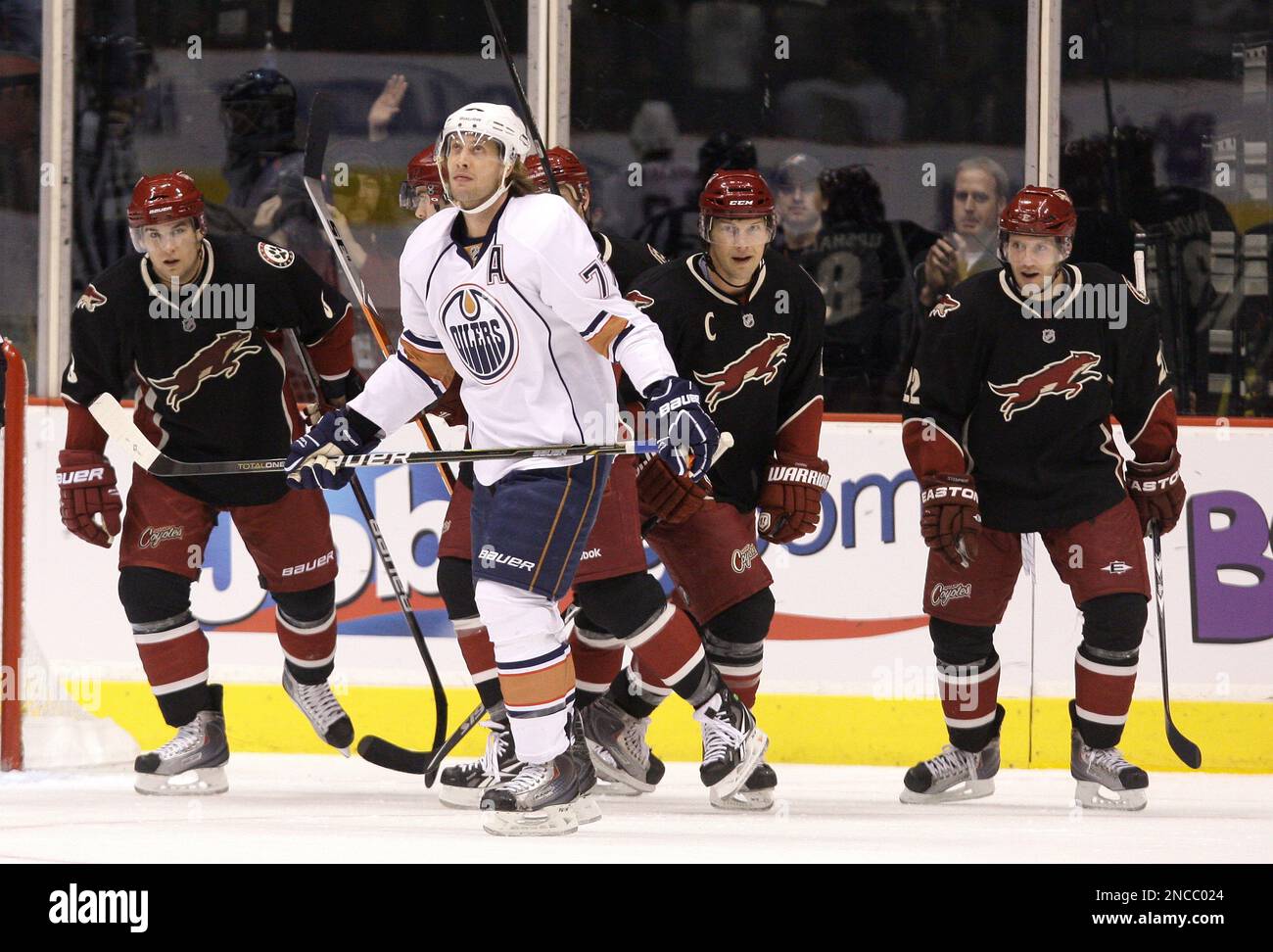 Edmonton Oilers' Tom Gilbert, front, skates away from Phoenix Coyotes ...