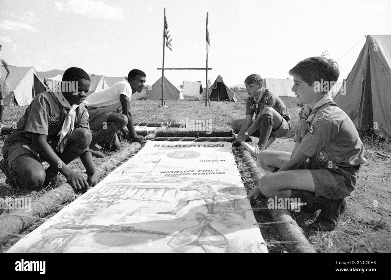 Four members of a Houston, Texas scout troop prepare to raise a banner ...