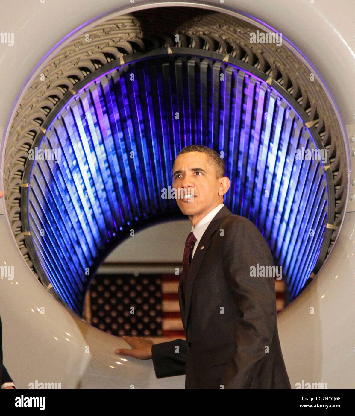 President Barack Obama stands in front of a generator as he visits the ...