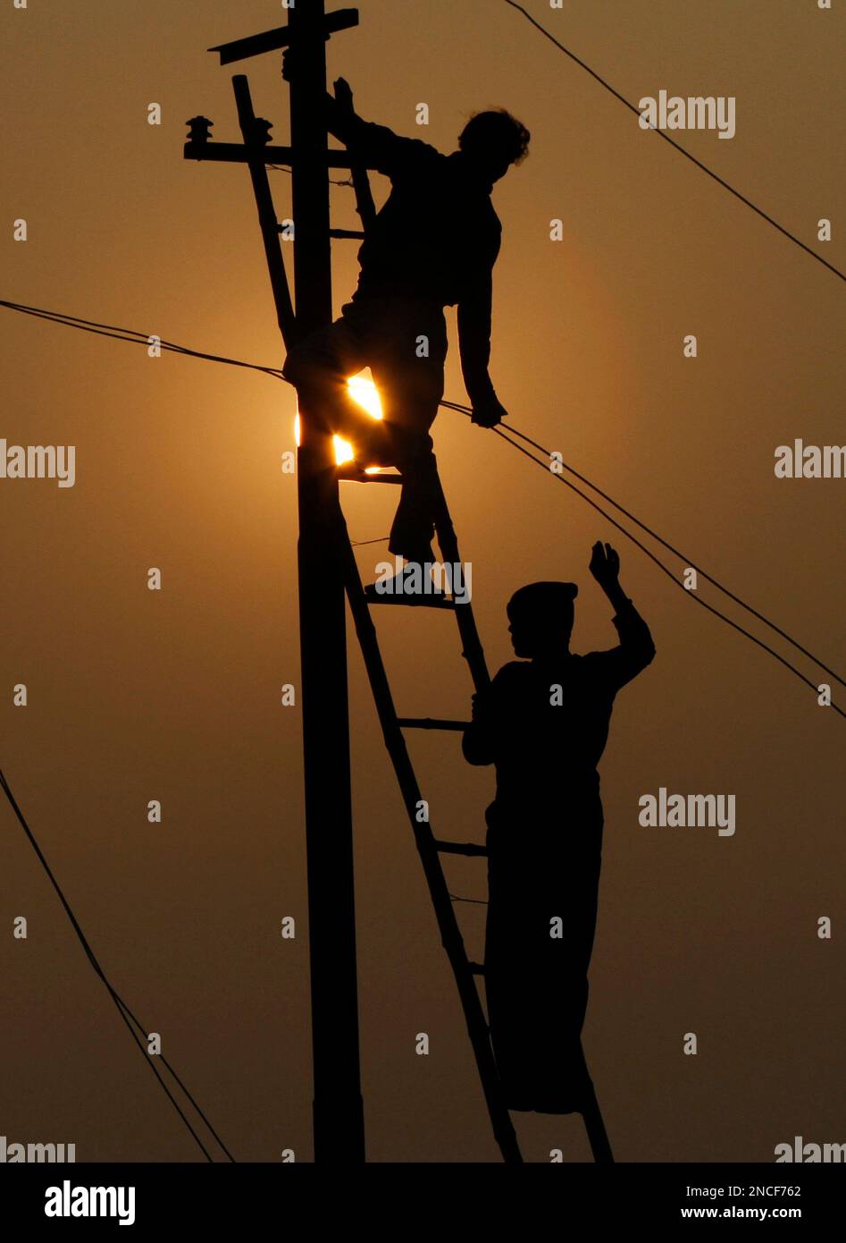 Indian linemen fix new high tension electric power line on the banks of ...