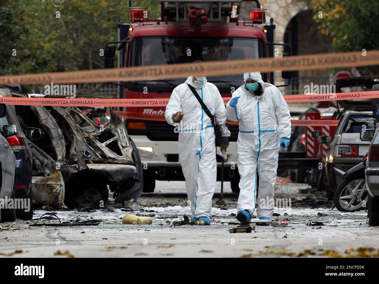 Police forensic experts gather evidence at the scene of a motorcycle bomb in that damaged two ...