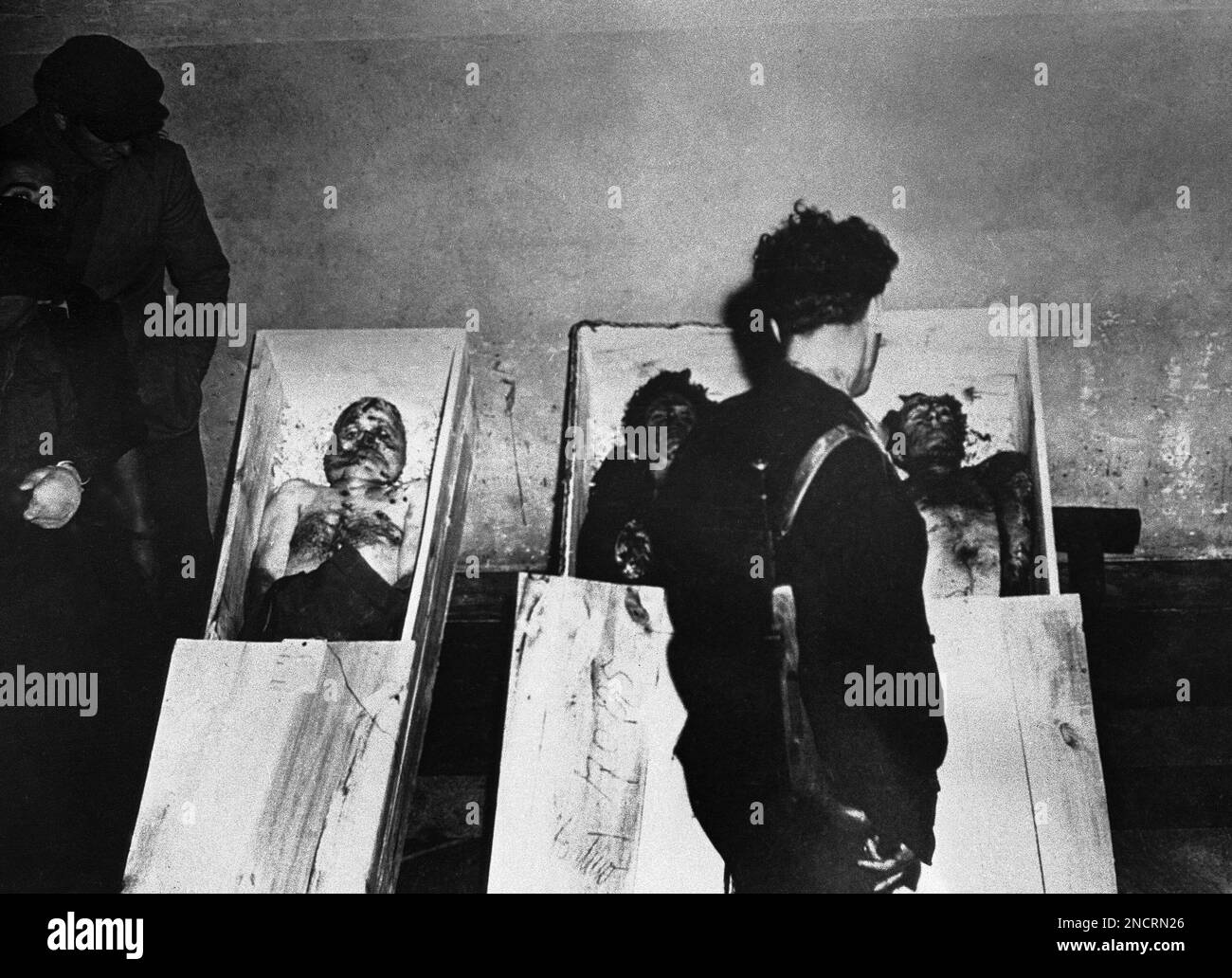 Partially visible in their crude wooden boxes in a Milan morgue on Oct ...