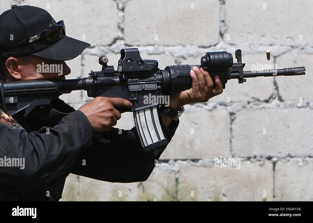 A SWAT member of the Philippine National Police fires at his target as ...