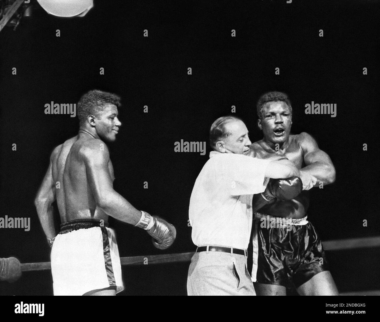 Referee Ruby Goldstein holds arms of Tommy “Hurricane” Jackson as he ...