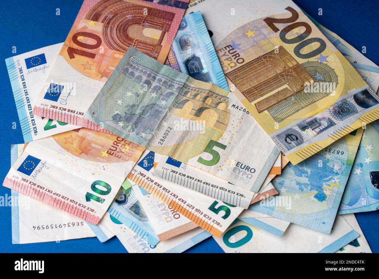 Sur la table se trouve un tas de billets en coupures de cinq, dix ...