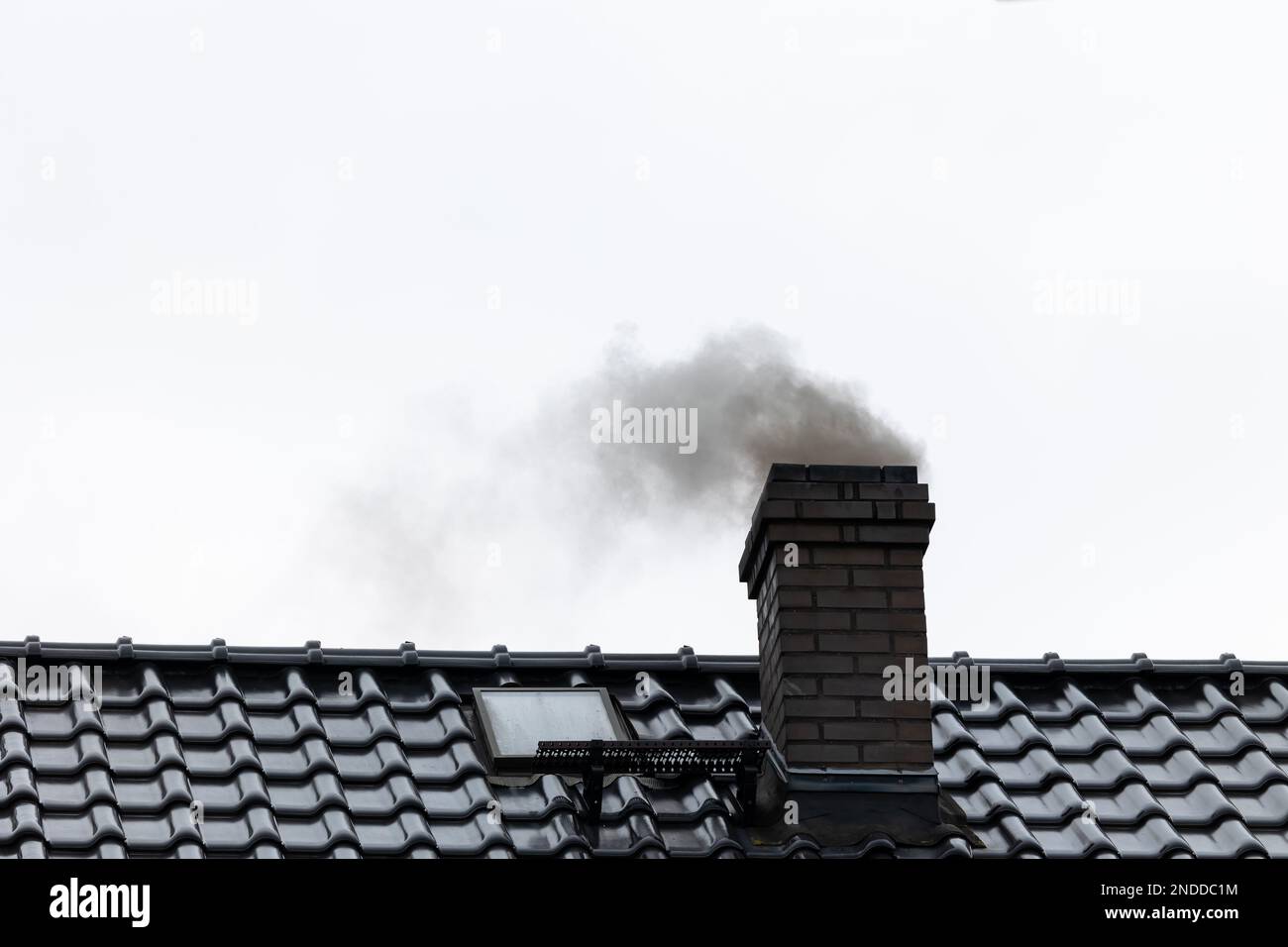 Fumée toxique volant de la cheminée d'une maison individuelle. Lutte ...