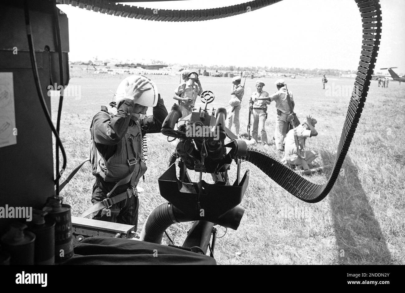 South Vietnamese helicopter crew chief adjusts his helmet before ...