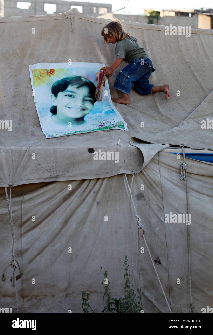 Palestinian Dia Awaja, 4, cleans a portrait of his late brother Ibrahim ...