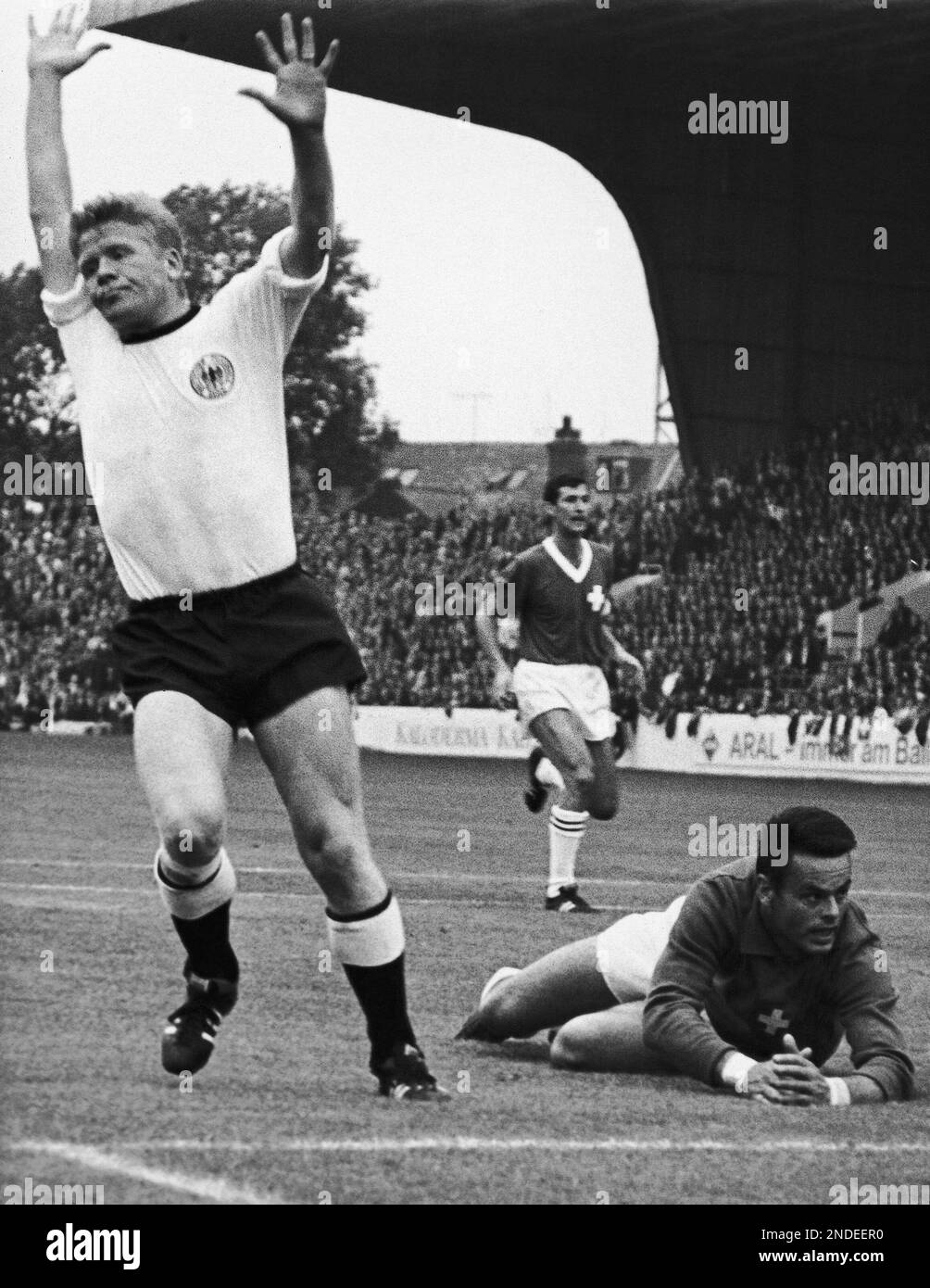 Helmut Haller of the West Germany World Cup football team raises his ...