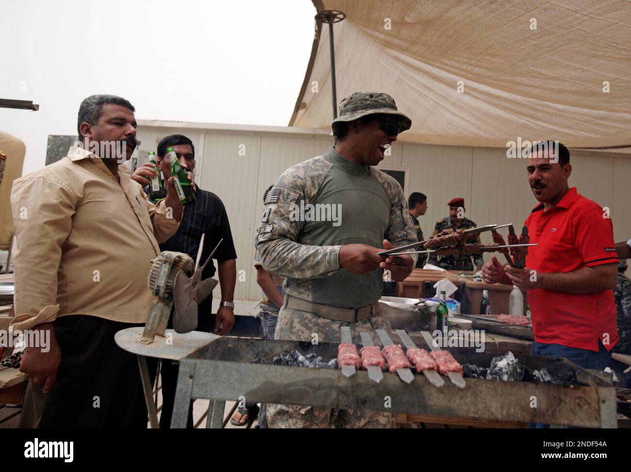 U.S. Army cook Sgt. Julius Geter, center, laughs as he gets advice on ...