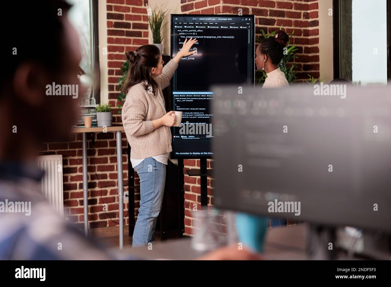 Équipe de codeurs parlant des algorithmes devant le grand écran ...