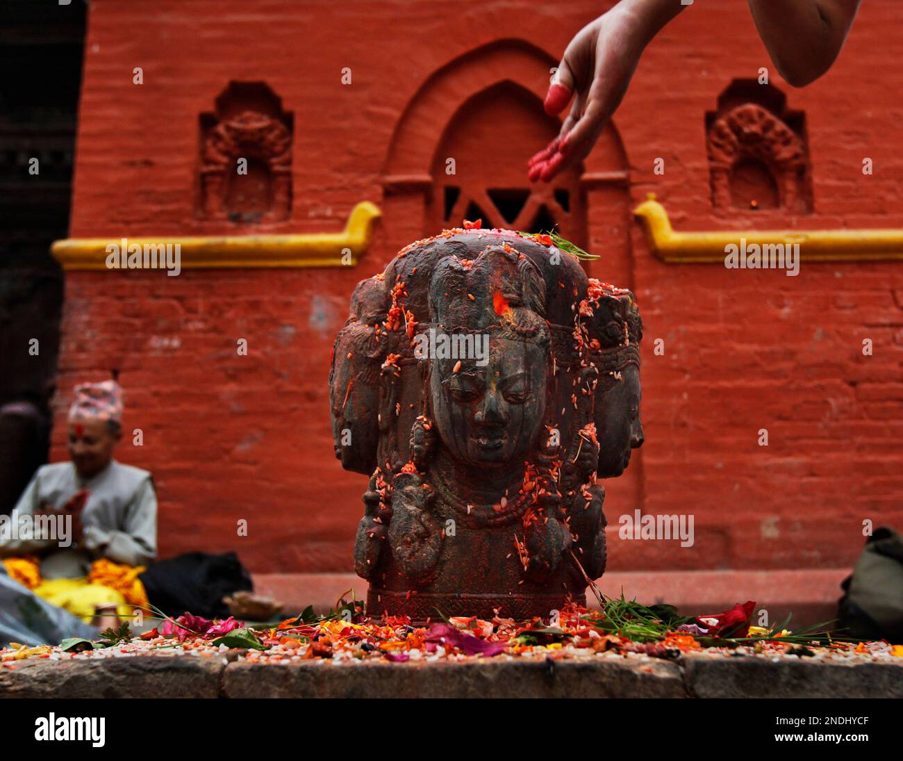 A Hindu devotee offers vermilion powder to a four-faced idol of Lord ...