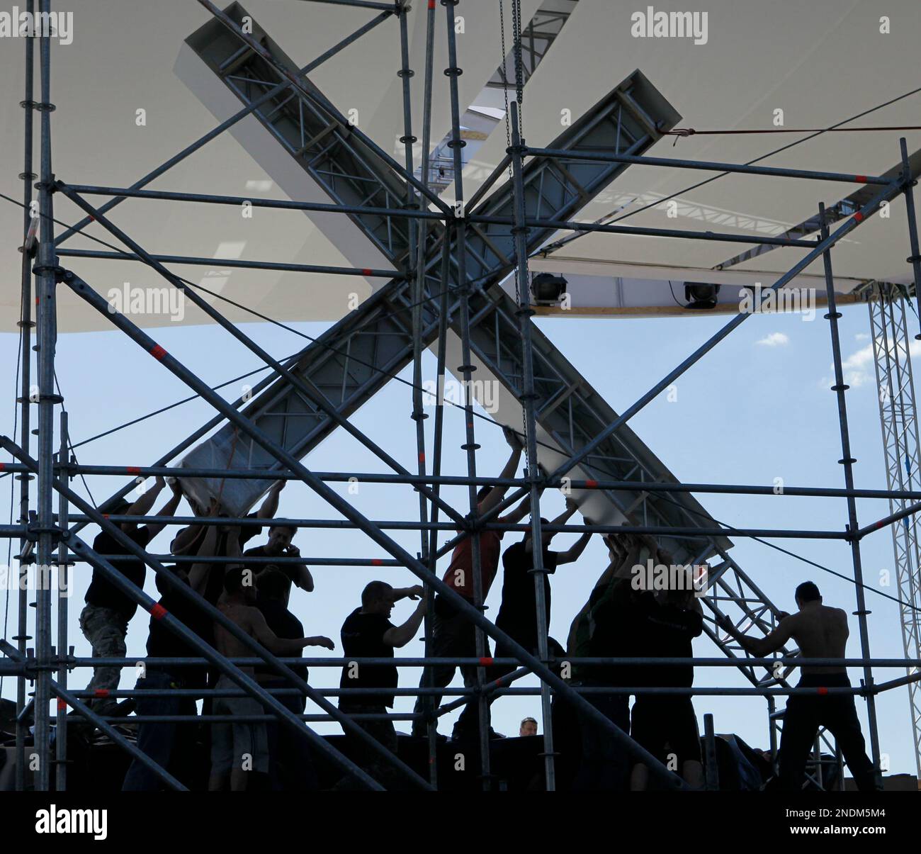Workers errect a cross as they build an altar for the Sunday ...