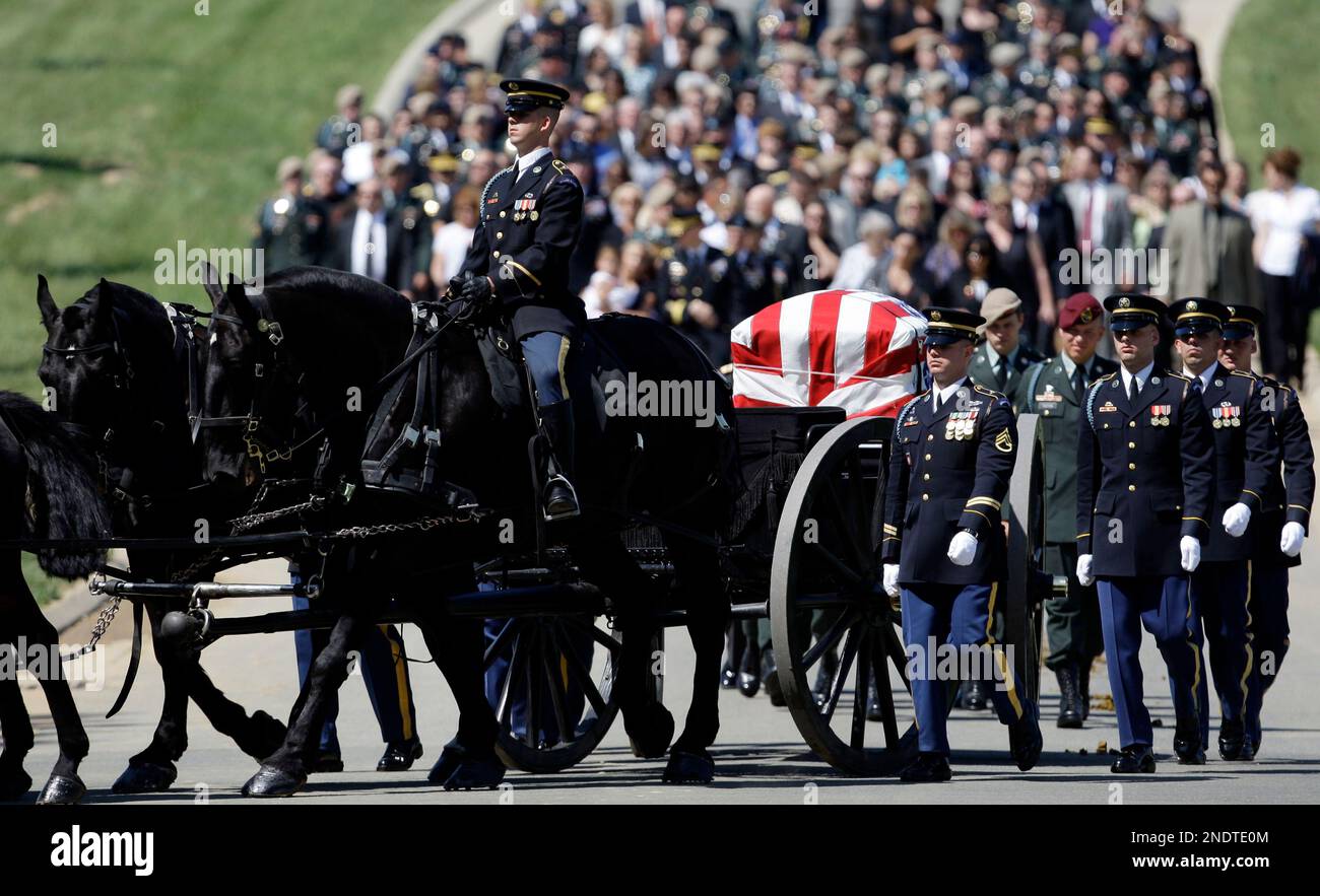 An honor guard and horse drawn caisson transports the casket carrying ...