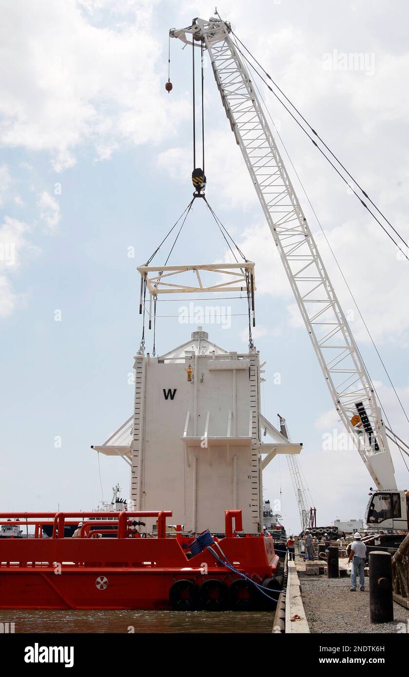 Workers at the Wild Well Control company load a chamber that will be ...