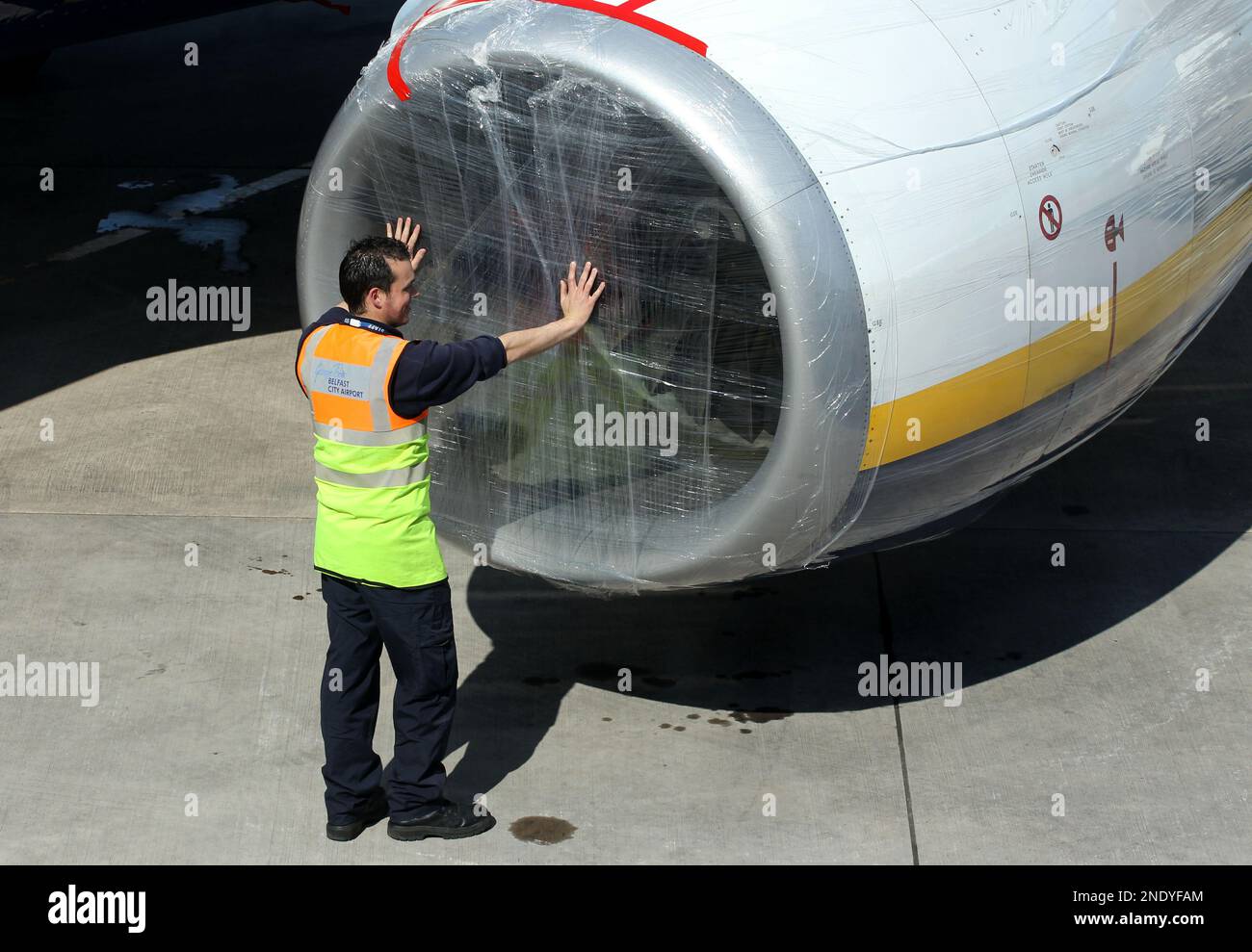 A aircraft maintenance worker covers a jet engine intake at Belfast ...