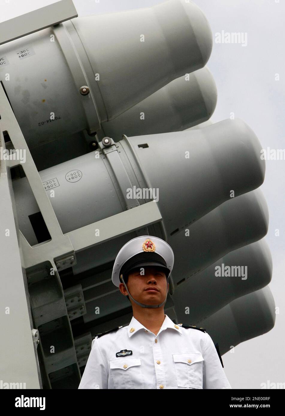 A Chinese Navy officer stands next to mounted missiles from the Chinese ...