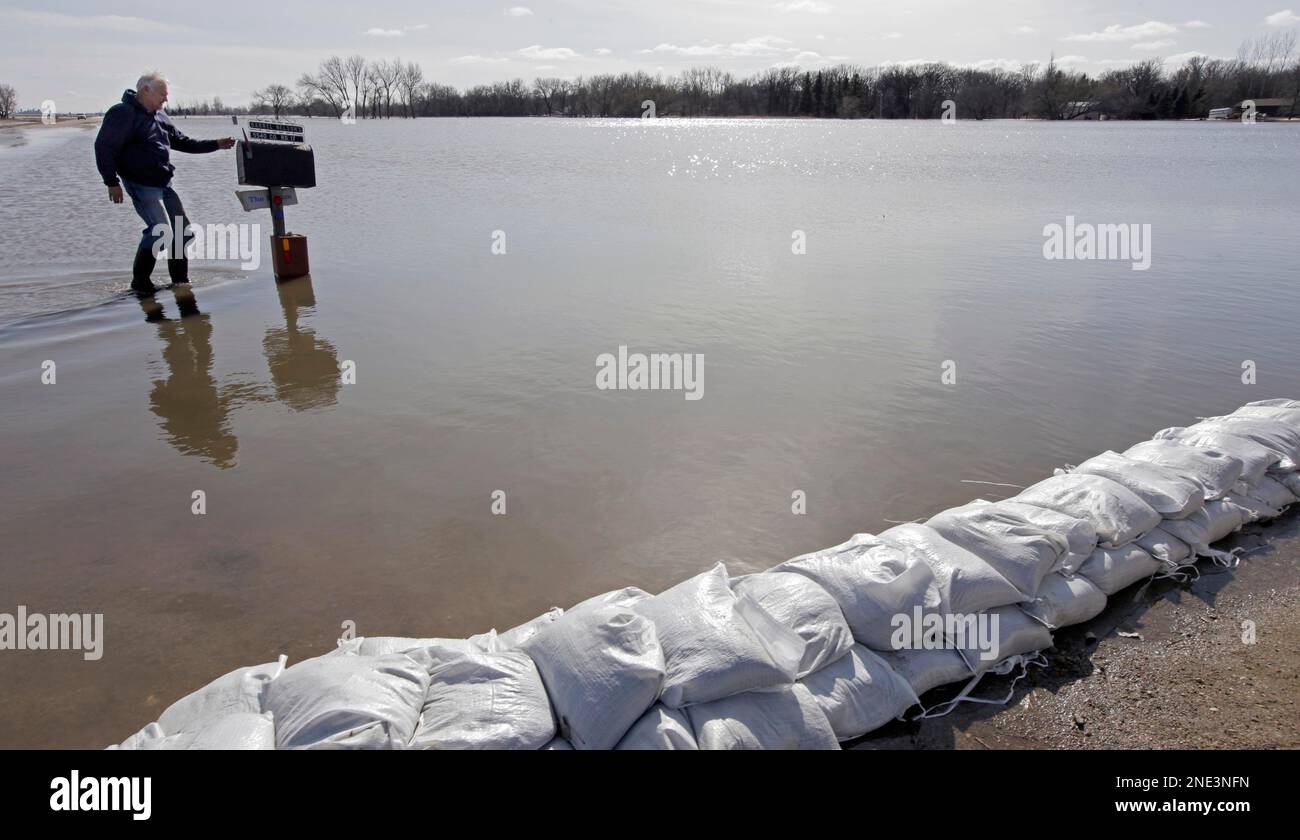Darrell Nelson wades through water caused by overland flooding from the ...